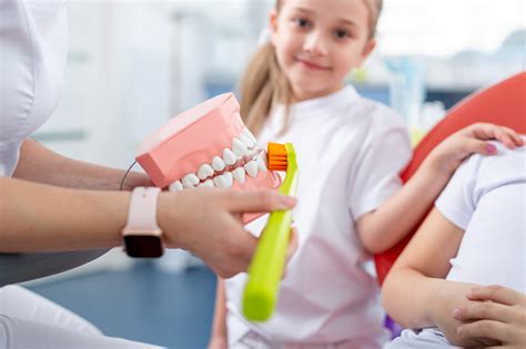 소아 치과 의사는 어린 아이들에게 치아를 제대로 닦는 방법을 보여줍니다 어린이 소년과 의사의 사무실에서 소녀 개념은 아이들의 치아의 건강입니다 25 29세에 대한 스톡 사진