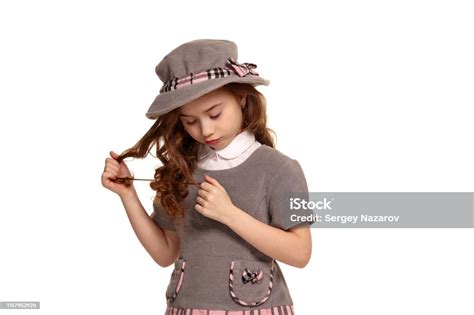 흰색 배경에 고립 된 포즈를 취한 길고 곱슬 한 머리카락을 가진 사랑스러운 어린 아이의 스튜디오 샷 갈색 머리에 대한 스톡 사진