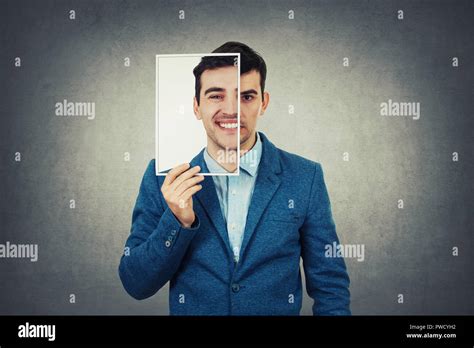 Portrait Of A Sad Businessman Hiding Half His Face Using A Photo Sheet