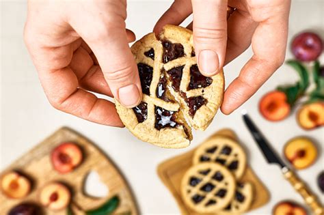 수제 매실 파이와 신선한 전체 및 슬라이스 매실 과일 상단 보기와 테이블 위에 매화 과일의 부스러기 맛있는 미니 타르트를 깨는 손 가을에 대한 스톡 사진 및 기타 이미지