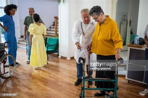 Nursing Assistant Helping Senior Man With Walking Frame Photos And