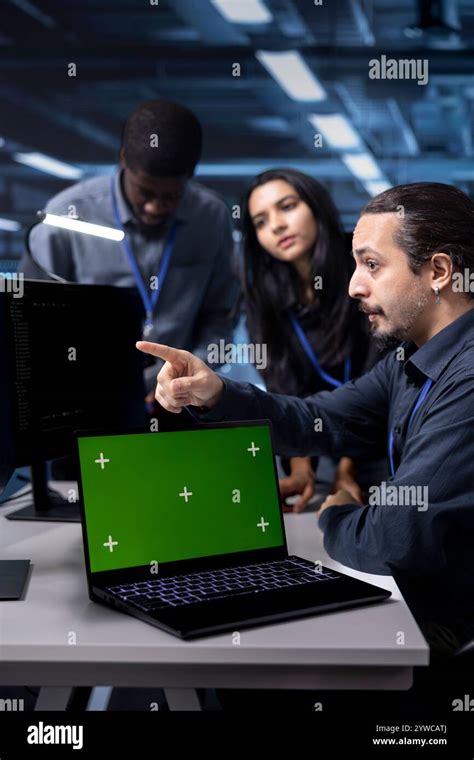 Multiethnic Team Of Engineers In Data Center Using System Monitoring Software On Green Screen
