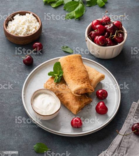맛있는 수제 팬케이크 또는 코티지 치즈가 들어간 크레페와 어두운 배경에 사워 크림이 든 접시에 신선한 체리 갈색에 대한 스톡 사진 및 기타 이미지 Istock
