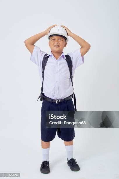 하얀 바탕 현수막에 배낭 가방과 안전 헬멧을 쓴 태국 교복을 입고 서 있는 어린 아시아의 귀여운 소년 학교로 돌아가기 14 15 살에 대한 스톡 사진 및 기타 이미지