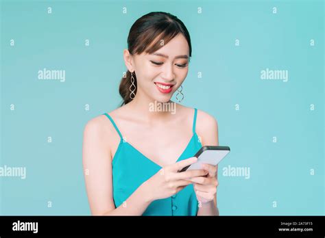 Attractive Woman Using Text Messaging Feature On Her Portable Device In Studio Stock Photo Alamy