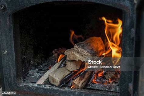 검은 금속 난로 안에서 불타는 장작을 클로즈업하여 타오르는 불씨와 주황색 불꽃이 통나무의 질감을 강조합니다 건조한에 대한 스톡 사진 및 기타 이미지 Istock