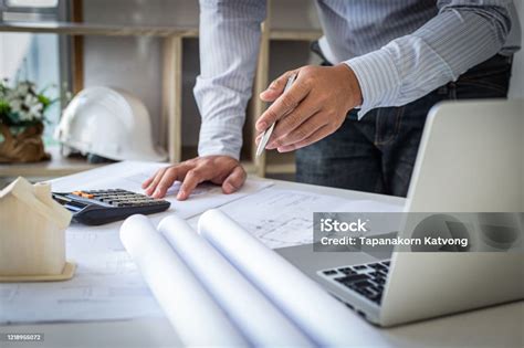 엔지니어는 청사진에 집 구조를 설계하고 건축가의 방에서 작업 노트북 펜 연필 도면 및 금형 샘플 하우스를 설계하기위한 장비가 있습니다 건설업자에 대한 스톡 사진 및 기타