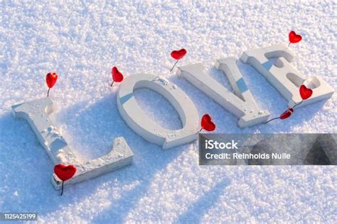 고립 된 단어의 근접 촬영 사랑 눈 속에서 나무 조각에서 레드 심장 장식 주위 흰색 배경으로 맑은 겨울 날에개념의 사랑 행복과 기쁨 발렌타인 데이에 감정에 대한 스톡 사진