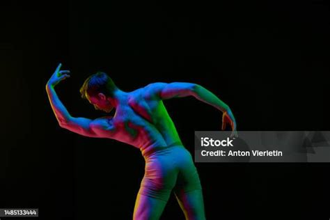 네온 불빛이 있는 어두운 스튜디오 배경 위에서 춤을 추는 남성 운동 프로 발레 댄서의 초상화 현대적인 스타일 맞는 젊은이 남성에 대한 스톡 사진 및 기타 이미지 Istock