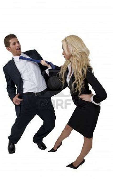 Female Pulling Tie Of Man On Isolated Background Couple Posing Photo