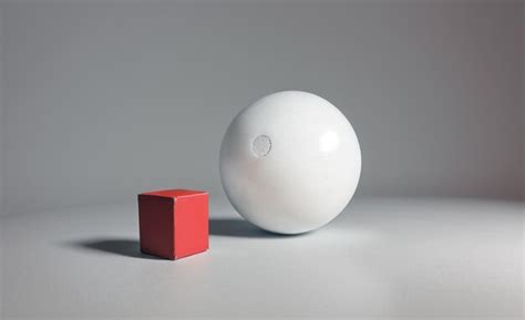 Premium Ai Image Contrasting Unity White Ball On Top Of Red Cube