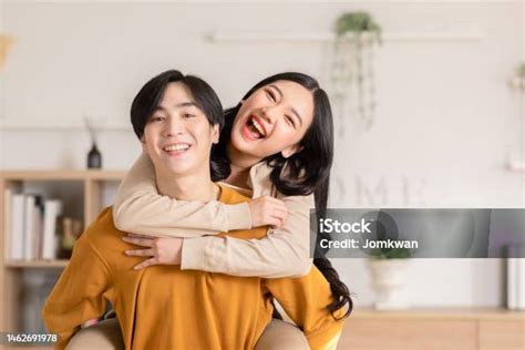 긍정적인 감정으로 포옹하고 따뜻한 곳에서 함께 사랑하는 아시아 젊은 부부 매력적인 남자와 여자는 집에서 함께 시간을 보내는 것을