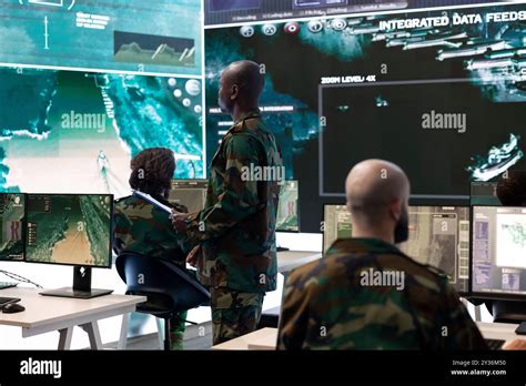 Military Personnel Undertaking A Secret Service Operation With Real Time Data On A Big Screen