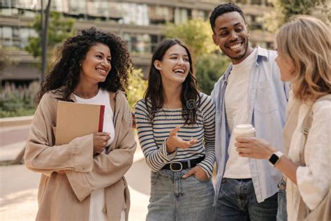 Happy Young Interracial Students Chatting With Each Other After Class