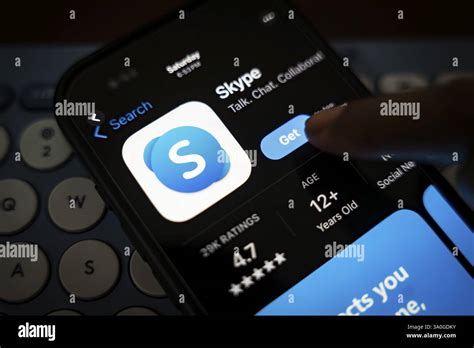 In This Photo Illustration A Person Holds A Mobile Phone Displaying Skype Application In