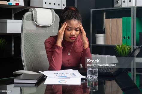 사려 깊은 젊은 아프리카계 미국인 사업가 그녀의 머리 뒤에 손을 잡고 사무실에서 책상에서 문서 작업 개념에 대한 스톡 사진 및 기타 이미지 Istock