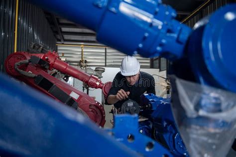 Engineer Inspection Control A Robot Arm Welding Machine With A Remote