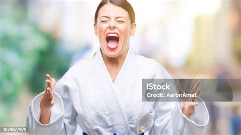 젊은 아름 다운 여자에가 라 데 기모노 유니폼을 입고 배경 미친 격리 하 고 미친 소리 하 고 적극적인 식와 팔 발생 함 좌절 개념입니다 가라테에 대한 스톡 사진 및 기타