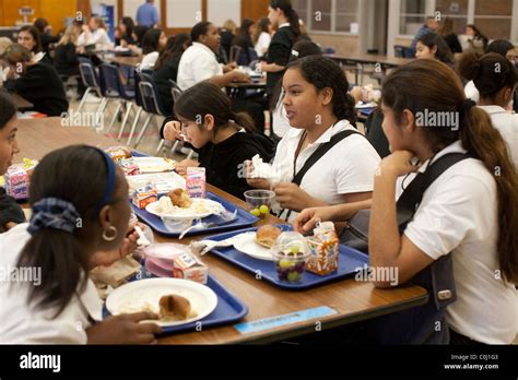 Middle School Girls Socialize During Lunch In The Cafeteria At The Ann