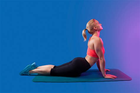 금발 여자는 파란색 바탕에 블루 요가 매트에 기지개에 종사 텍스트를 위한 공간 가냘픈에 대한 스톡 사진 및 기타 이미지 가냘픈 거리 건강한 생활방식 Istock