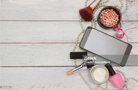 여성 화장품 및 Assesories스마트폰 Creame 립스틱 브러쉬 파우더 매니큐어와 흰색 나무 바탕에 매니큐어에 대 한 도구