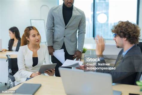 다양한 동료와 함께 사무실에서 일하는 휠체어를 사용하는 아시아 여성 건강관리와 의술에 대한 스톡 사진 및 기타 이미지 건강관리와 의술 경영자 기업 문화 Istock