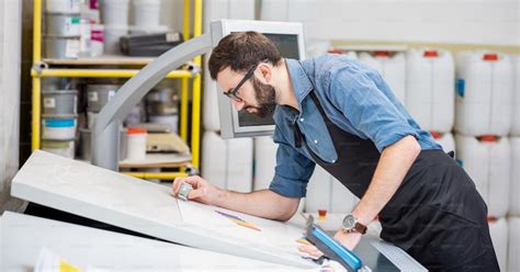 인쇄 제조의 수술대에서 돋보기로 인쇄 품질을 확인하는 작업자 사진 Unsplash의 공장 이미지