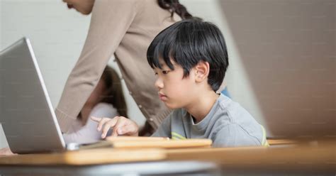 국제 초등학교에서 노트북 컴퓨터로 공부하는 일본 소년 사진 Unsplash의 선생 이미지
