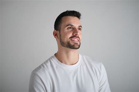 행복한 백인 잘생긴 밀레니얼 세대 남성이 옆을 바라보며 큰 미소를 지으며 서 있는 허리 위로 사진 흰색 배경에 대한 스톡 사진 및 기타 이미지 Istock