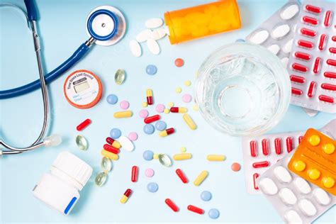 파란색 배경 의료 약국 개념 알약 더미 위에 맑은 물 한 잔과 다채로운 알약 사진 및 무료 다운로드를위한 그림 Pngtree