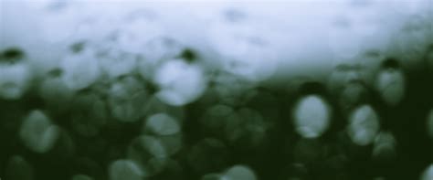 유리에 빗방울이 있는 분위기 있는 최소한의 단색 배경 비오는 물방울과 먼지 얼룩이 있는 젖은 창문이 클로즈업됩니다 빗방울이 있는 더러운 창 유리의 흐릿한 미니멀리스트 배경이