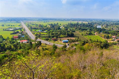 시골 녹색 쌀 필드와 푸른 하늘 배경 주위 언덕에서 고속도로 통해 공중 볼 수 있습니다 자동차와 트럭 피 성 태국에서 언덕을 넘어 지방 고속도로 경관에 대한 스톡 사진 및