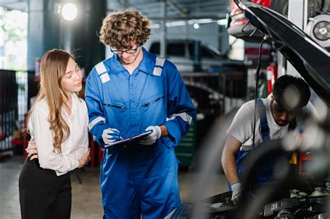 자동차 수리 서비스 센터 전문 서비스 정비사가 클립 보드를 들고 차고에있는 아시아 여성 고객에게 자동차 검사 목록 및 수리 품목을 보여줍니다 3 명에 대한 스톡 사진 및