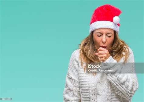 중 년 수석 히스패닉 여자 기분이 불쾌 하 고 감기 나 기관지염에 대 한 증상으로 기침 하는 고립 된 배경 위에 크리스마스 모자를 쓰고 의료 개념입니다 감기와 독감에 대한