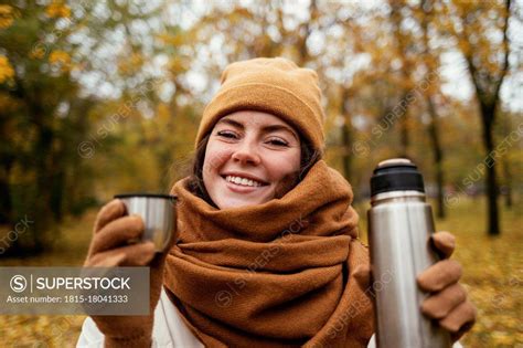 Smiling Young Woman With Insulated Drink Container At Autumn Park