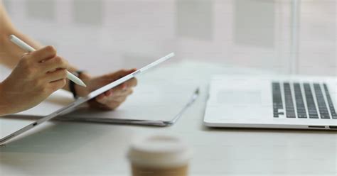 노트북과 종이컵이 있는 작업 공간에서 디지털 태블릿으로 작업하는 여성 손의 측면 보기 사진 Unsplash의 컴퓨터 키보드 이미지