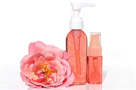 장미와 함께 화장품 추출합니다 젤과 토 닉 핑크 색상의 투명 한 플라스틱 병 및 테리 큰 분홍색 꽃 흰색 배경에 장미 장미 추출 물 식물 자연 화장품 개념 Diy에 대한