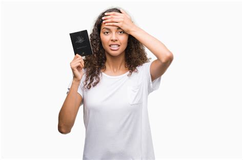 젊은 스페인 여 자가 머리에 손으로 압박 호주의 여권 들고 충격 수치심과 깜짝 얼굴로 분노와 좌절 두려워 하 고 실수에 대 한 화가 감정에 대한 스톡 사진 및 기타 이미지