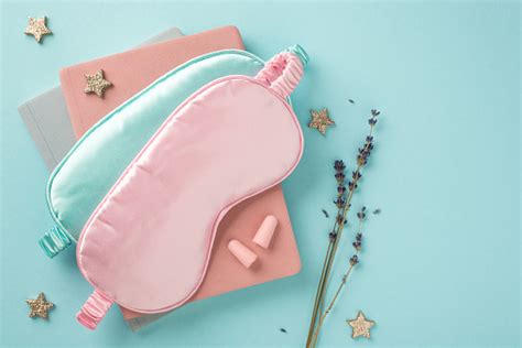 빈 공간이있는 고립 된 파스텔 블루 배경에 빛나는 별과 라벤더의 잔가지에 파란색과 분홍색 실크 수면 마스크 귀마개 의 상단 보기 사진 다이어리에 대한 스톡 사진 및 기타