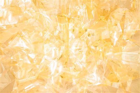 따뜻한 밝은 빛과 반짝이는 크리스탈 얼음 반사와 보케 빛과 홀로그램 무지개 빛깔의 금속 호일 리본 장식의 추상 빛나는 축제 메리 홀리데이 배경 텍스처 이미지 라이트 골드