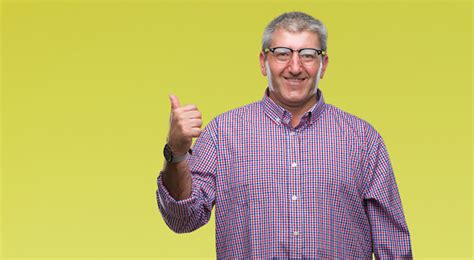 잘생긴 수석 남자가 생기고 엄지 측면 가리키는 행복 한 얼굴로 웃 고 고립 된 배경 위에 안경을 쓰고 있다 가리키기에 대한 스톡 사진 및 기타 이미지 Istock