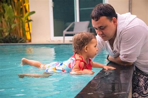 아버지는 수영복을 입은 귀여운 유아 어린 소녀를 가르치고 손을 잡고 수영장에서 수영을합니다 18 23 개월에 대한 스톡 사진 및 기타 이미지 Istock