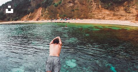 물 한가운데있는 바위 위에 서있는 남자 사진 Unsplash의 무료 수영 이미지