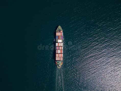 A Container Ship Moves Steadily Through The Ocean Carrying Stacked