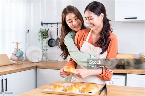 아시아 아름 다운 레즈비언 여자 커플 보기 에 여자 친구 빵 크루아상 매력적인 두 여성 게이 친구는 여가 시간을 보내고 부엌에서 함께 포옹즐길 수 있습니다 동성애lgbtq