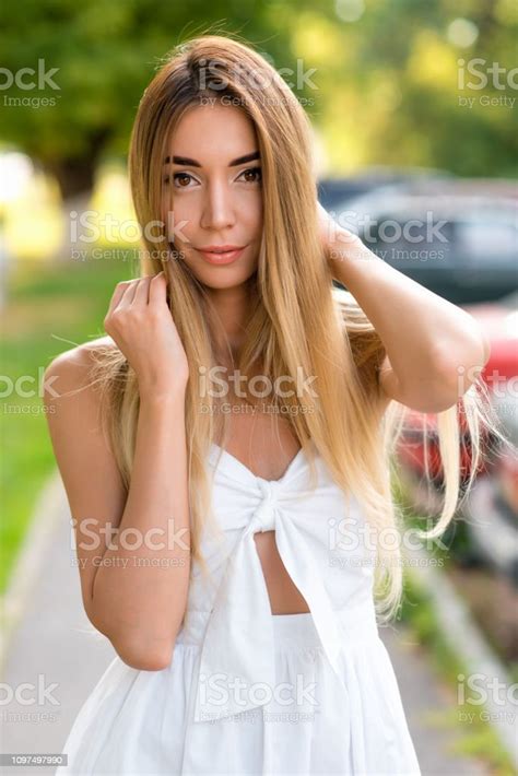 공원에서 여름에 드레스에 긴 머리와 아름 다운 여자 신선한 공기에 포즈 비즈니스 여자 행복 한 미소입니다 검게 그을린된 피부와 섬세 한 메이크업입니다 갈색 머리에 대한 스톡