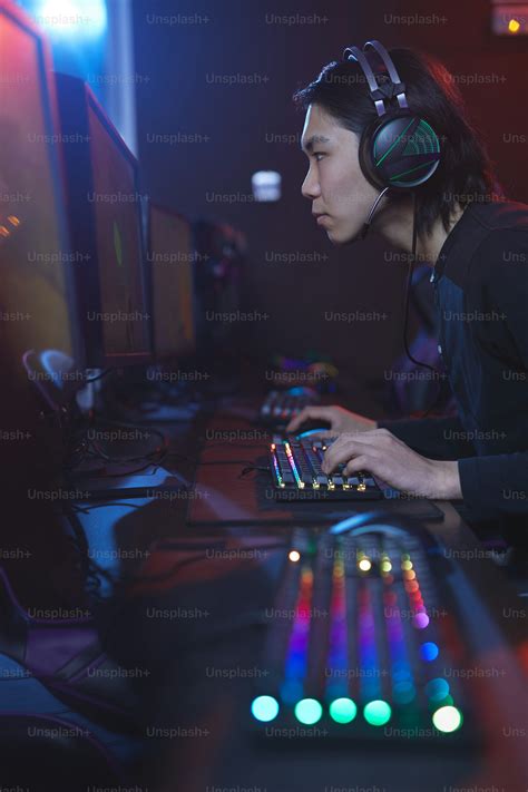 사이버 해킹 스튜디오에서 컴퓨터를 사용하는 젊은 아시아 남성의 수직 측면 초상화 복사 공간 사진 unsplash의 컴퓨터 이미지