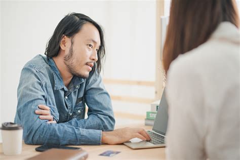 젊은 아시아 남자와 여자는 앉아서 집에 있는 침실에서 노트북 컴퓨터를 보고 있습니다 부부는 온라인 쇼핑을 고려 하 고 있습니다