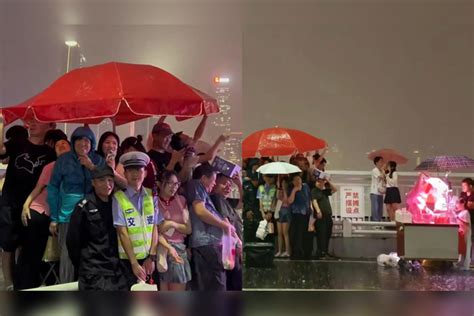 一场突如其来的大雨躲雨的人们笑着挤在一把伞下场面拥挤却温馨