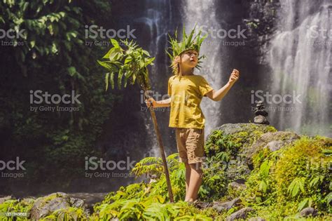 귀여운 소년은 폭포를 배경으로 정글의 왕을 묘사합니다 가제트 개념없이 어린 시절 어린이 개념과 함께 여행 어린 시절 야외 개념 미소에 대한 스톡 사진 및 기타 이미지